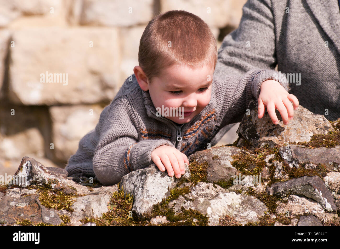 Boy climbing over wall hi-res stock photography and images - Alamy