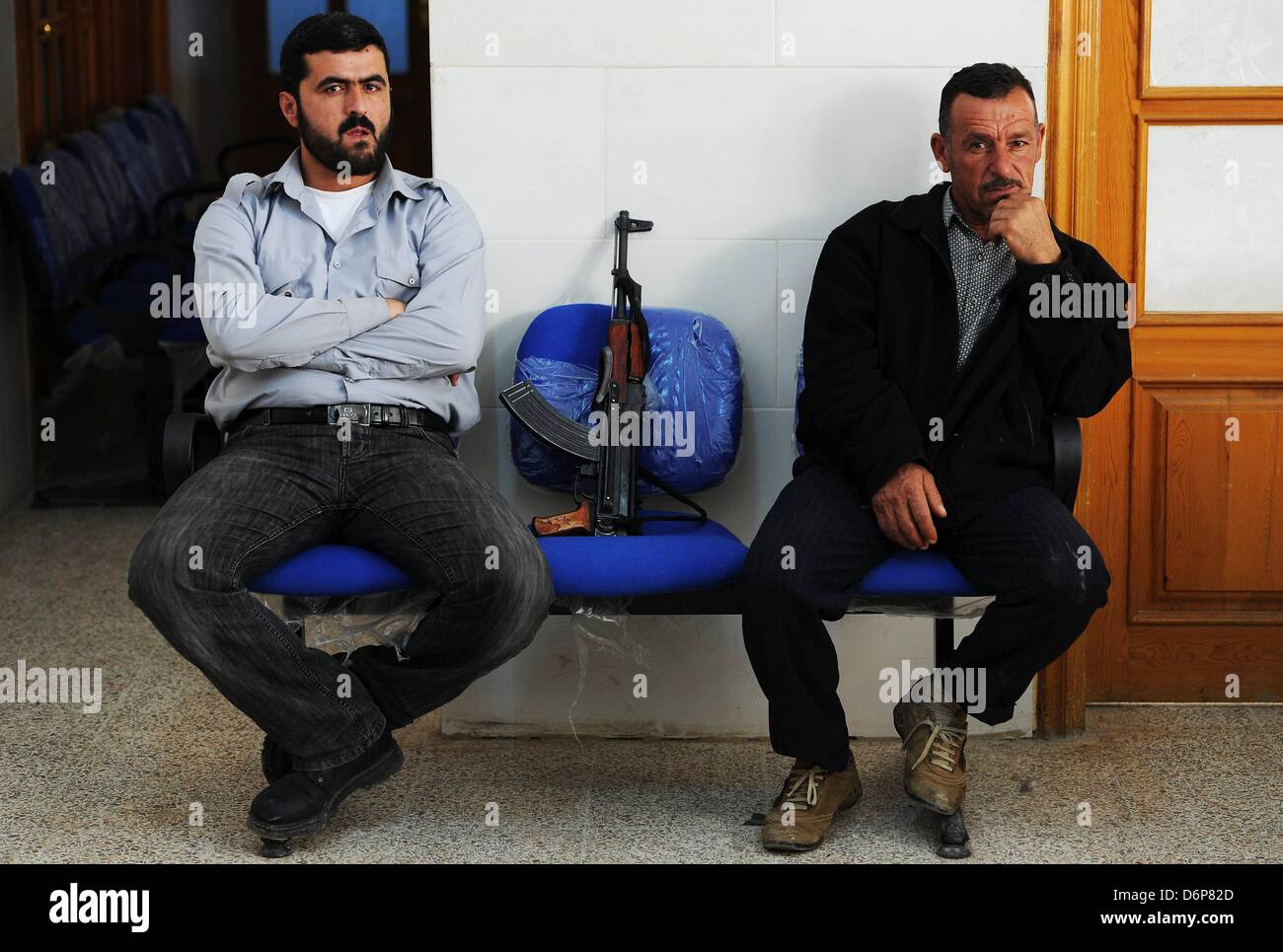 DARKOUSH, SYRIA: Two security guards sitting with an AK-47 assualt ...