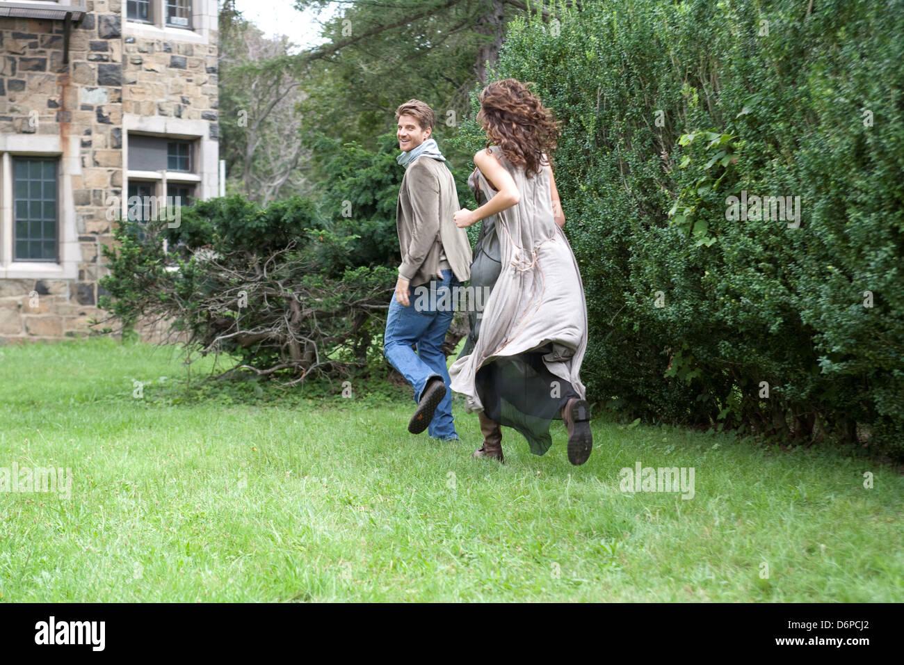 Young couple running in back yard Stock Photo - Alamy