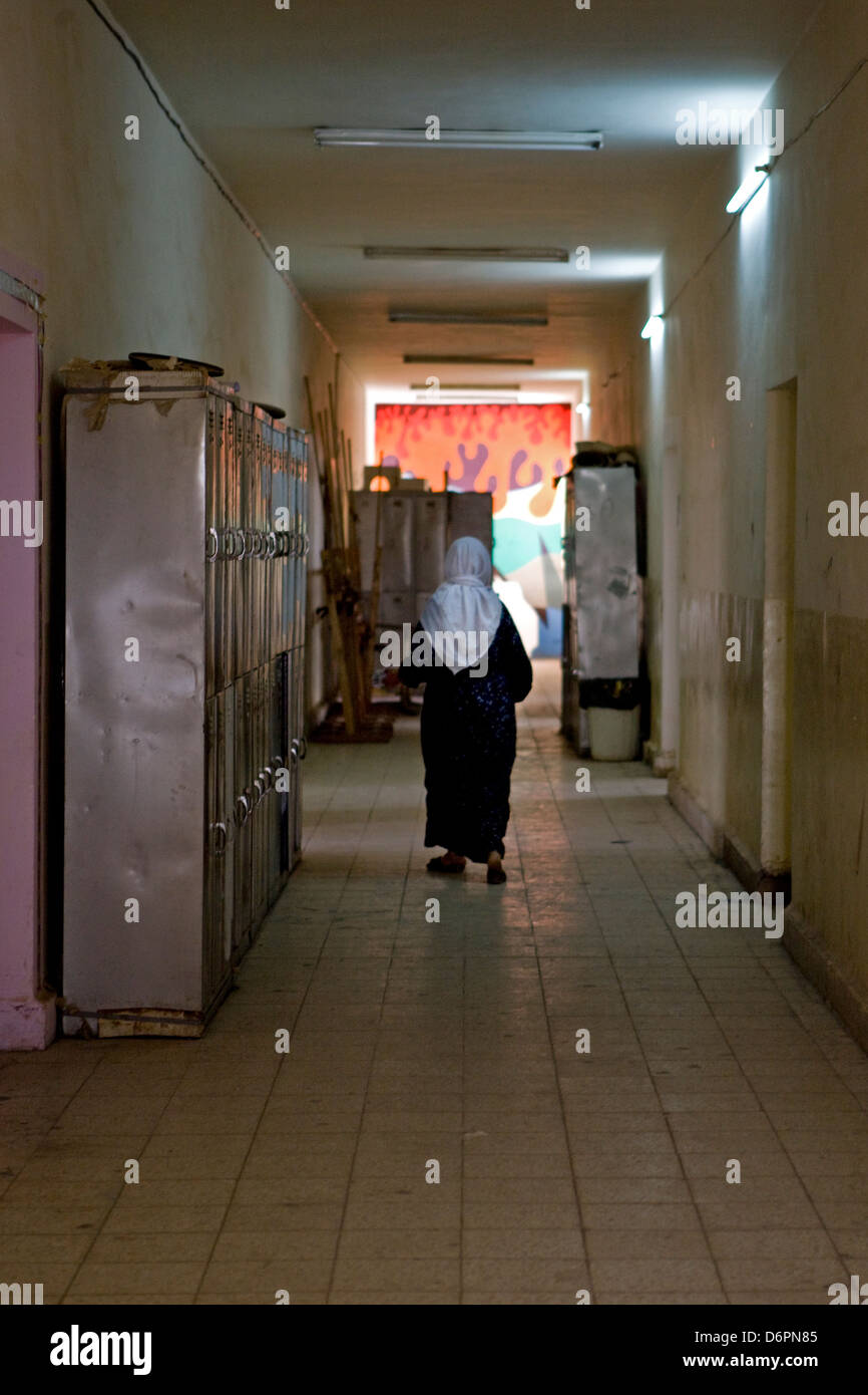 A female student wearing a traditional burka walks down the corridor in ...