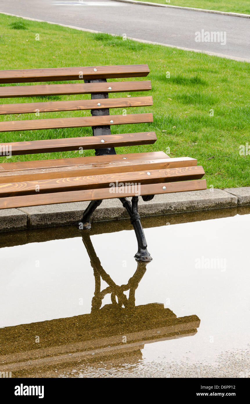 A bench and reflection in the park after the rain Stock Photo - Alamy