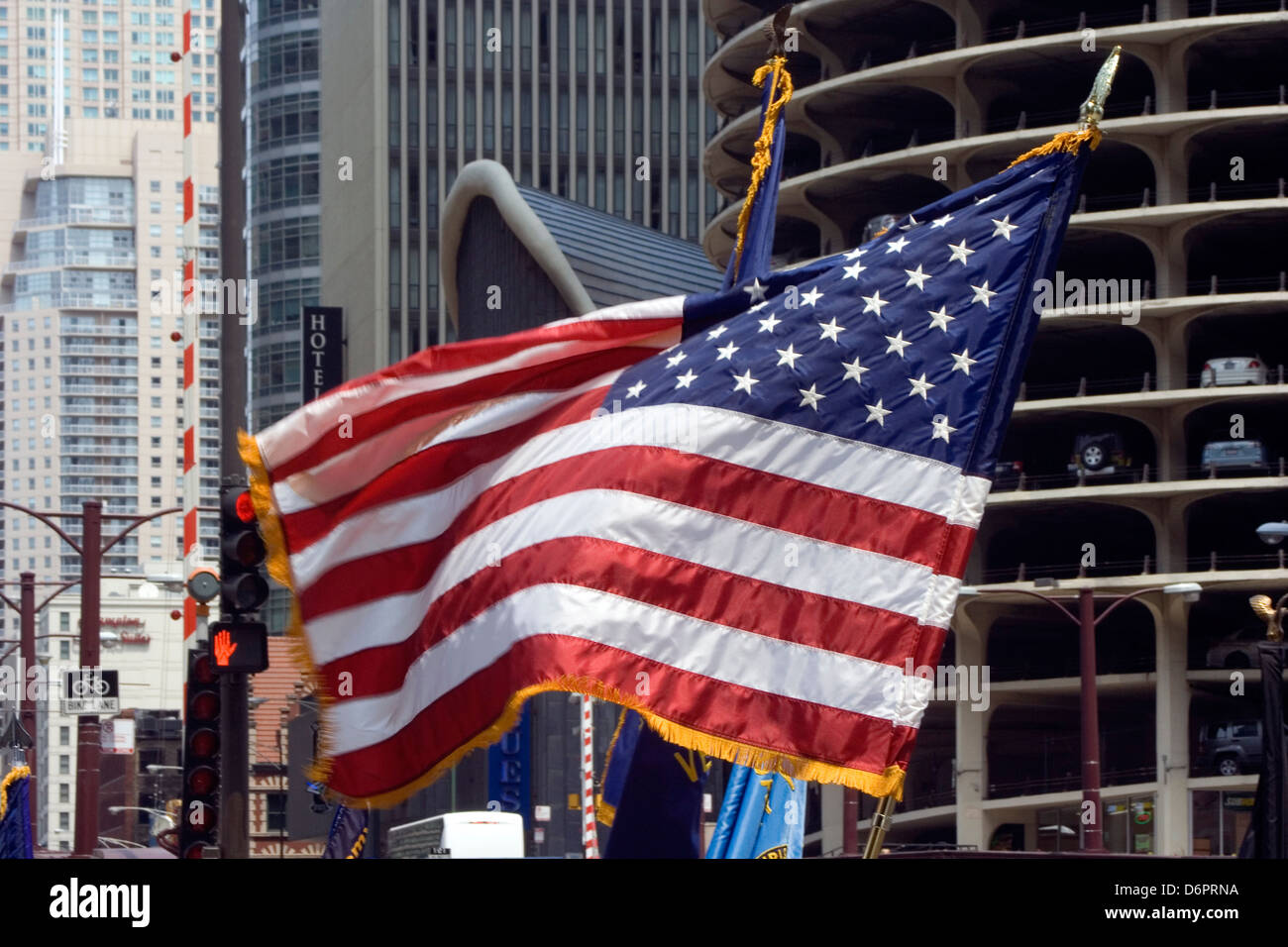 USA, Chicago, American flag passing Dearborn Street and Marina City ...