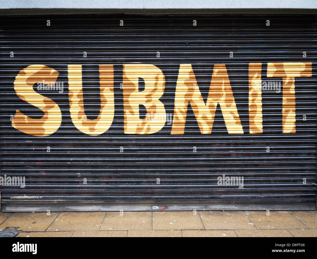 Submit written on shutter in Manchester UK Stock Photo - Alamy