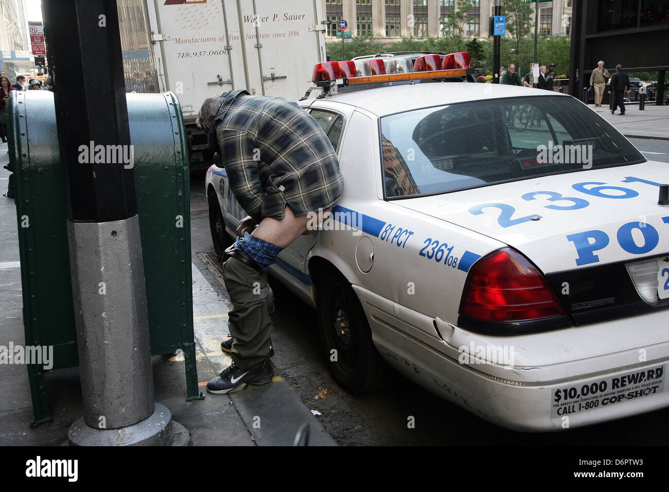 An unidentified man seen defecating on an NYPD patrol car in downtown ...