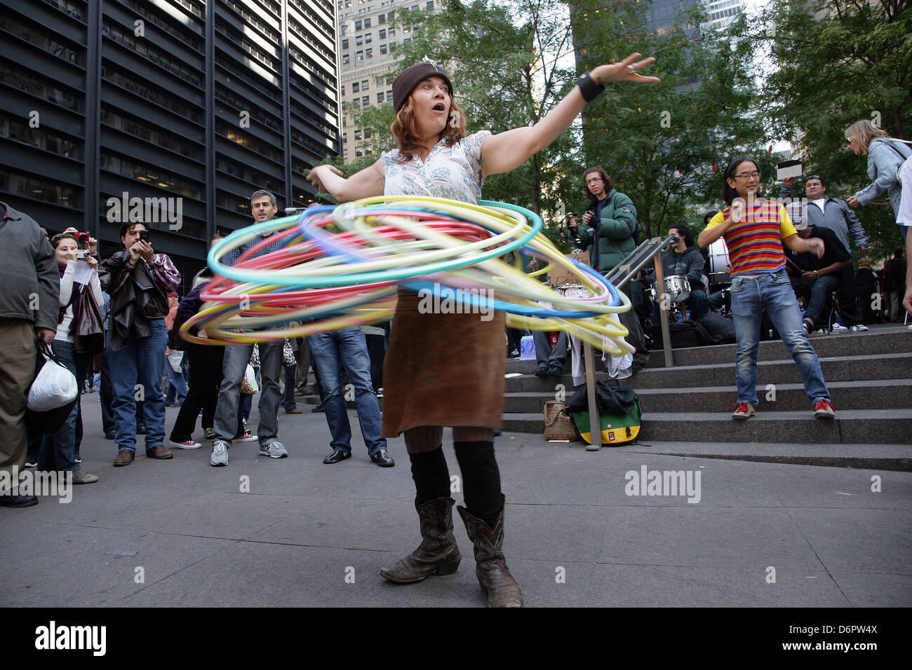 A female protester entertains the passing crowds by hula hooping Occupy ...