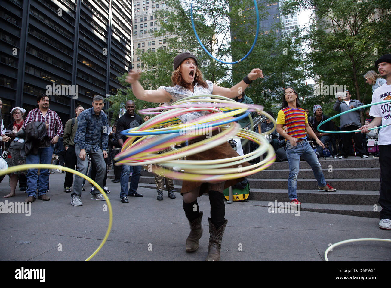 A female protester entertains the passing crowds by hula hooping Occupy ...