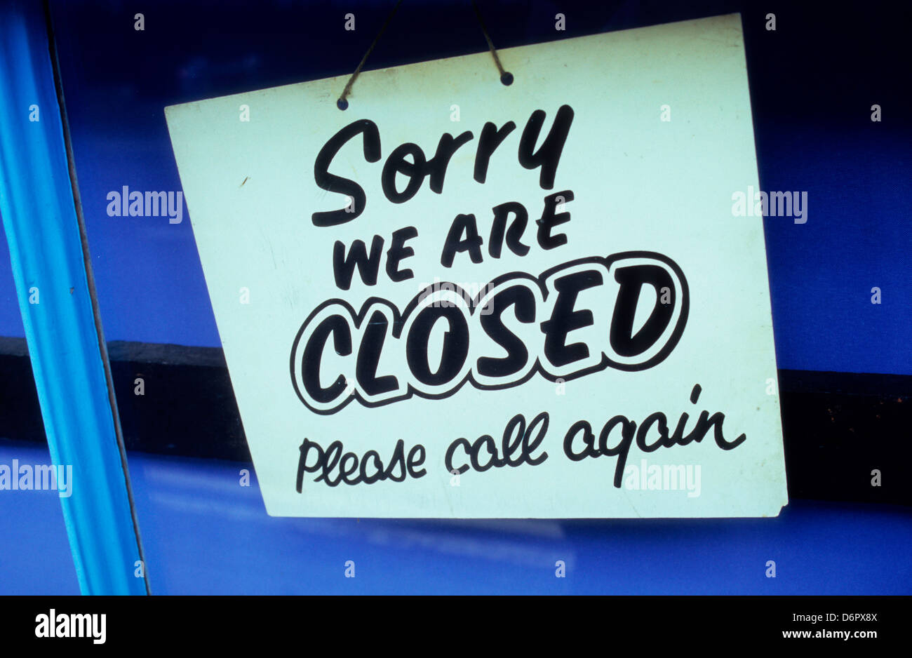 Detail of a shop door with sign stating Sorry We Are Closed Please Call ...