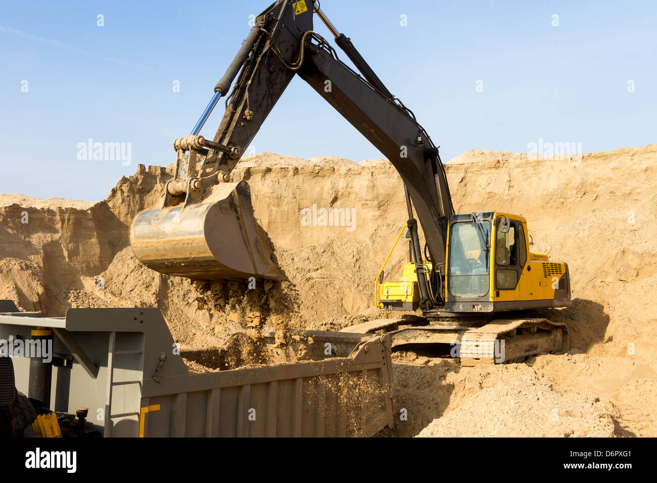 Excavator Loading Dumper Truck at Construction Site Stock Photo - Alamy