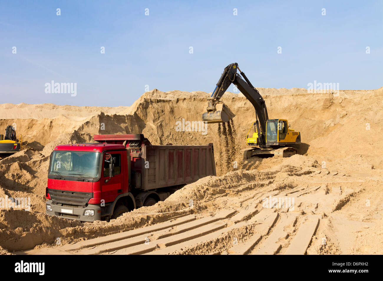 Excavator Loading Dumper Truck at Construction Site Stock Photo - Alamy