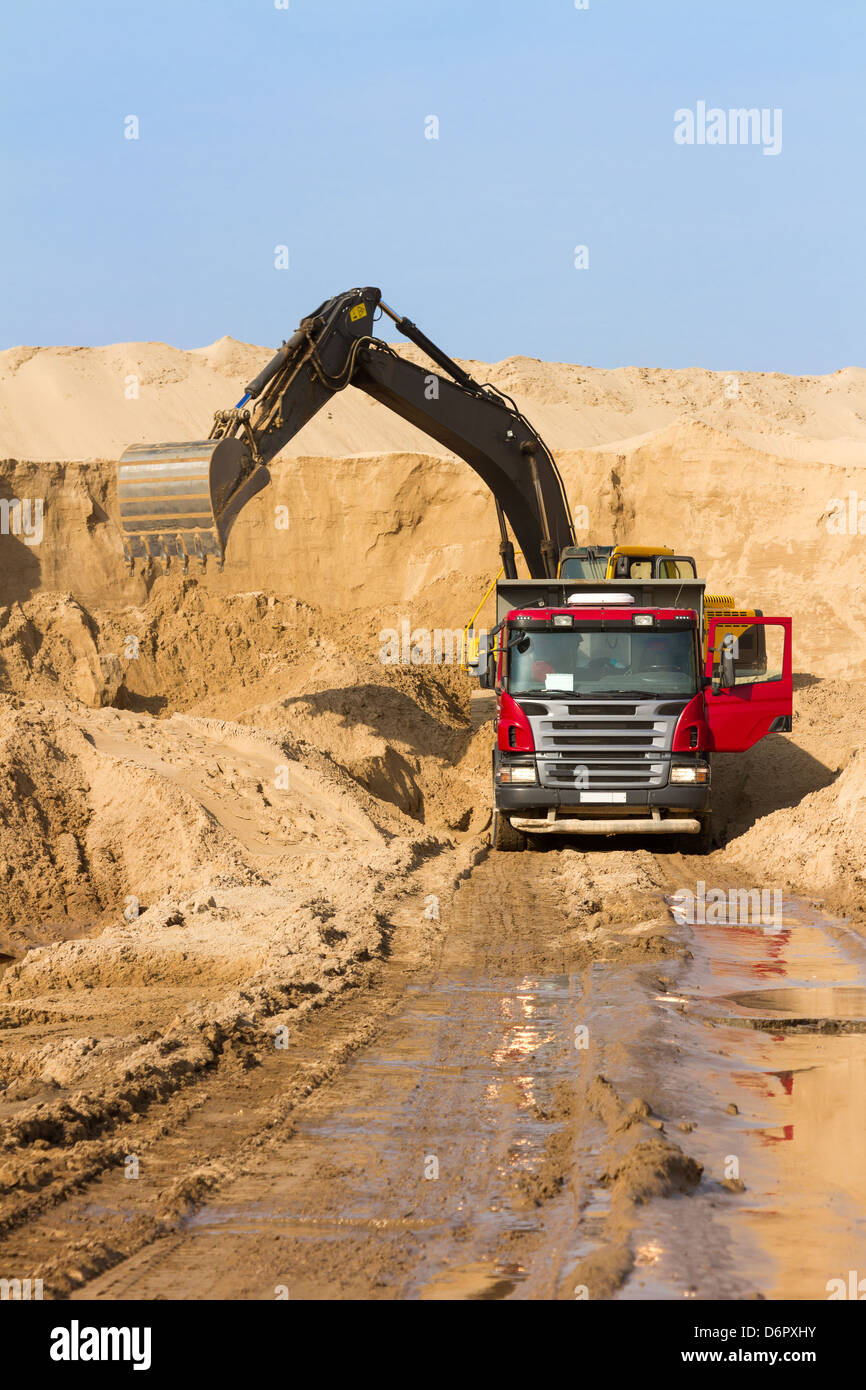Excavator Loading Dumper Truck at Construction Site Stock Photo - Alamy