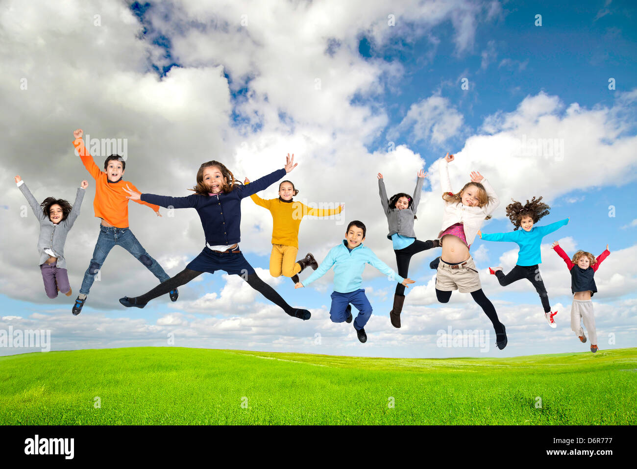 Group of children jumping outdoors Stock Photo - Alamy