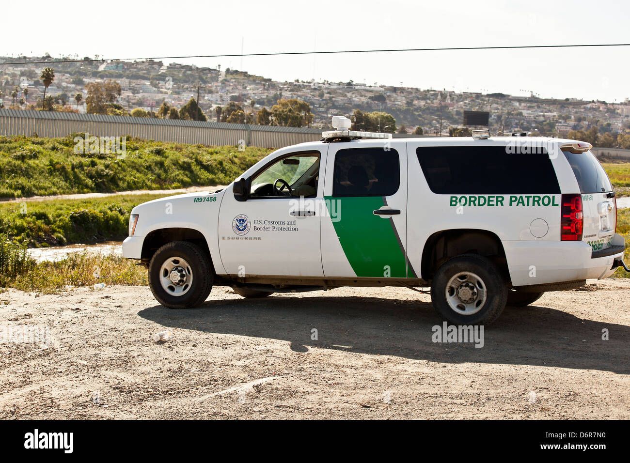 US Customs and Border Patrol officers watch the fence separating San ...