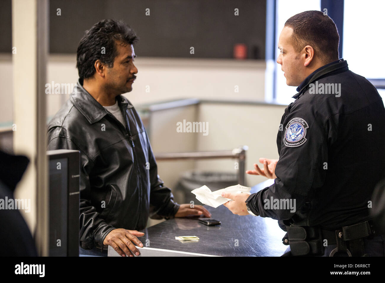 A Us Customs And Border Patrol Officer Checks The Identification Of A