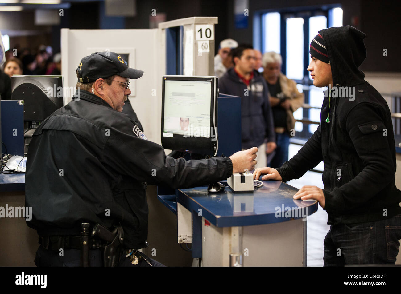 A US Customs and Border Patrol officer checks the identification of a ...