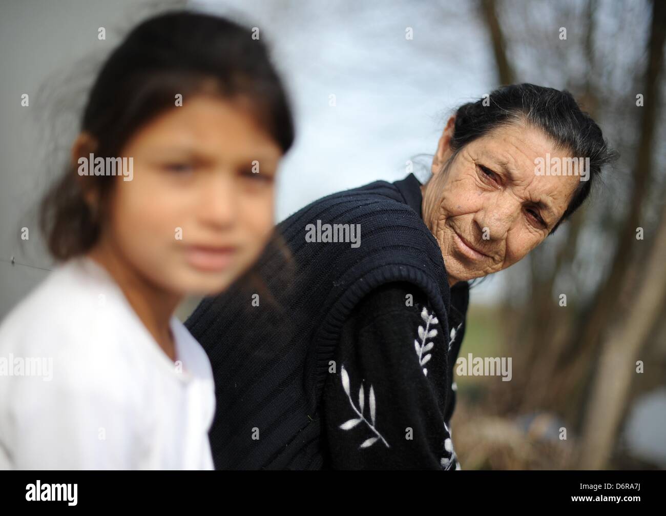 Sarah and her mother Bega (R) sit outside in front of their container ...