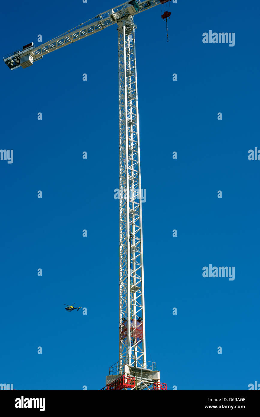 A crane towering above a London construction site set against a clear ...