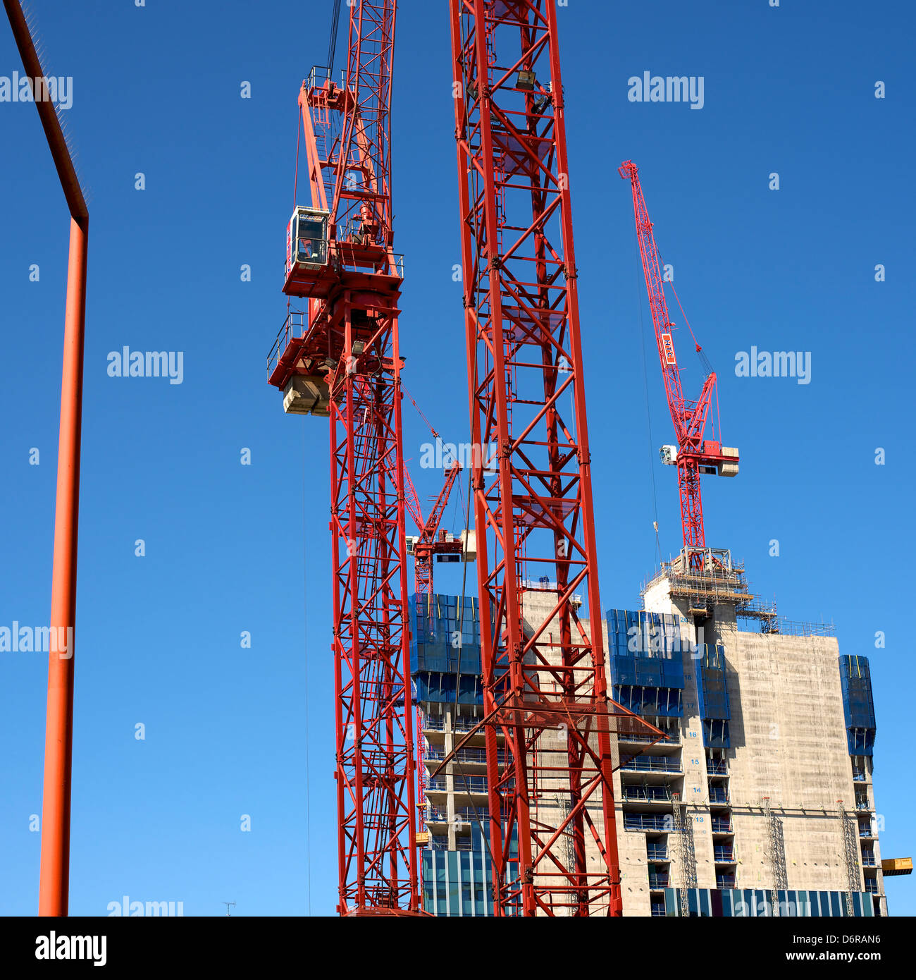 Four red cranes and a lamp post towering high up above a building site ...