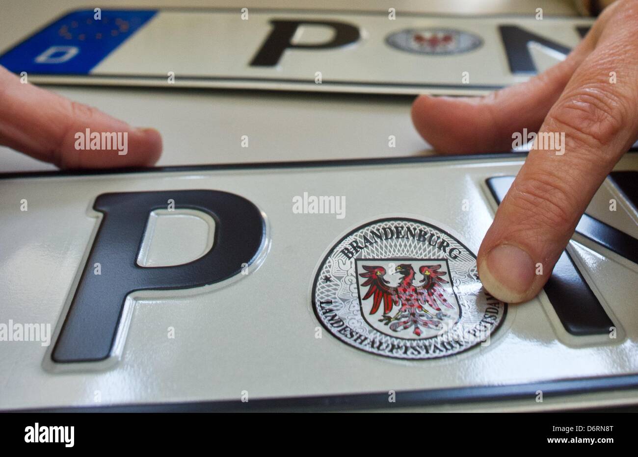 A badge of the state of Brandenburg is attached to a new licence plate ...