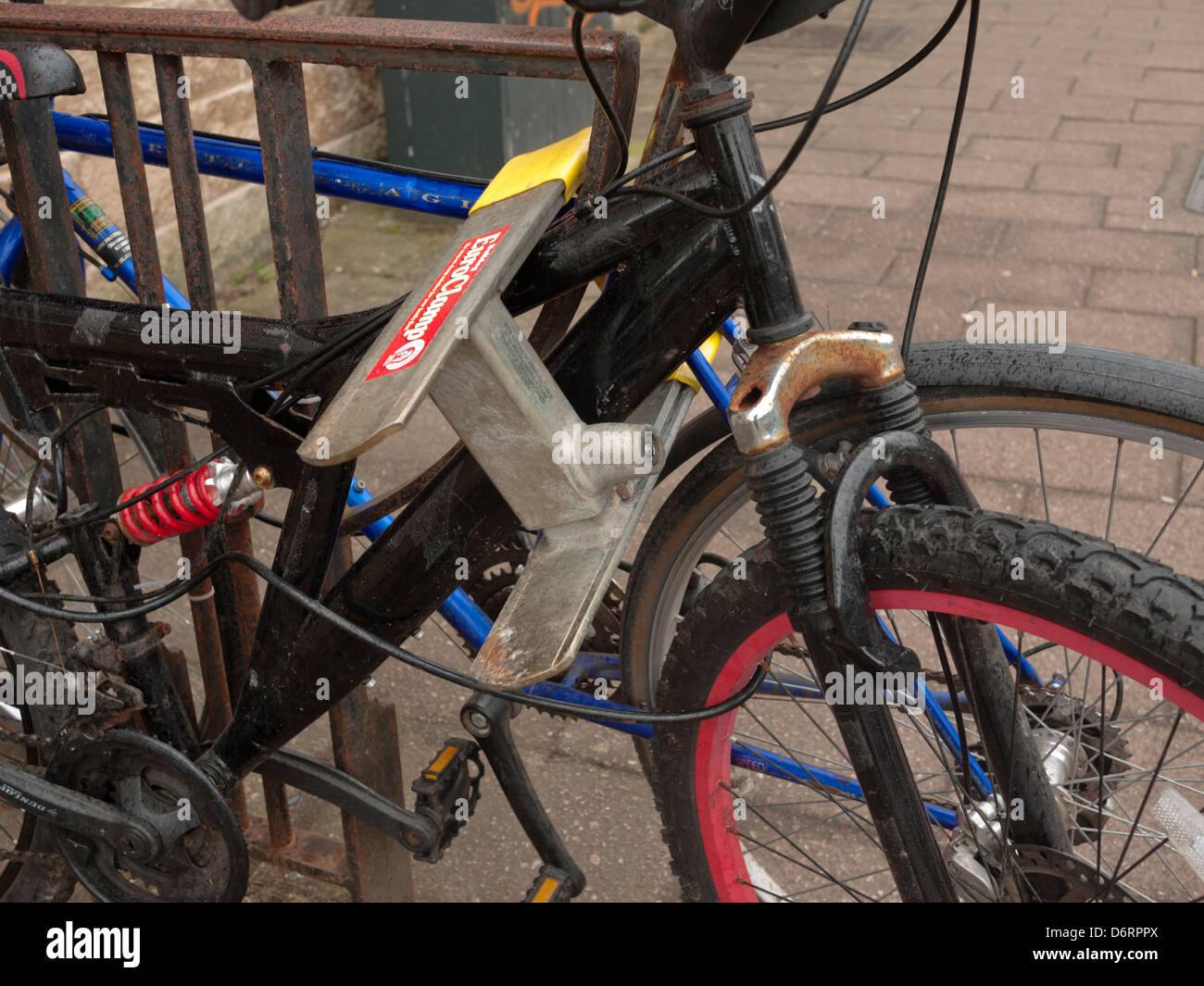 Two bicycles locked to a bike rack using a heavy duty car wheel clamp ...