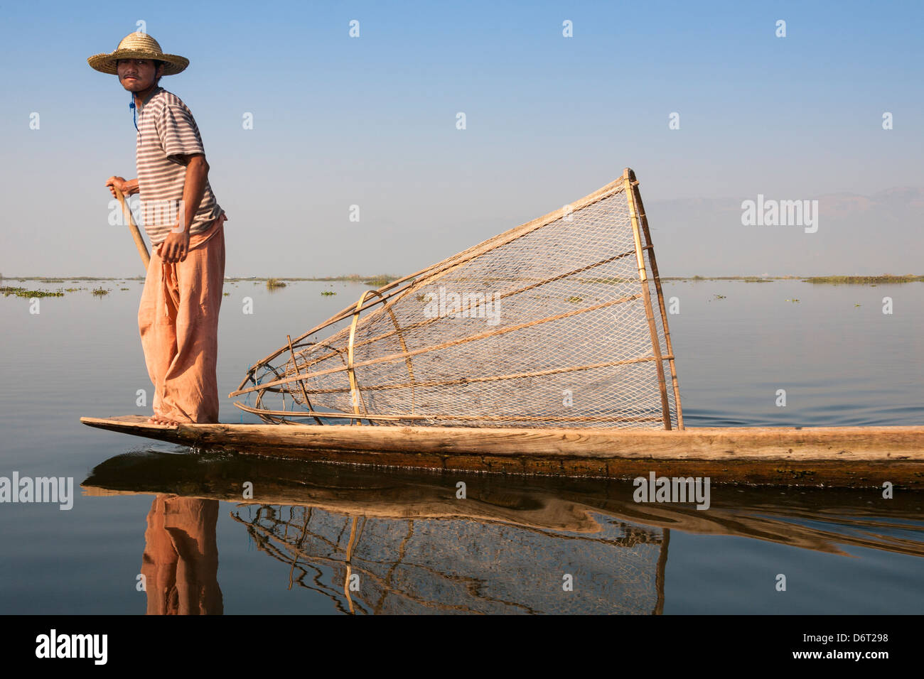 Intha fisherman fishing in a traditional fishing boat, Inle Lake ...