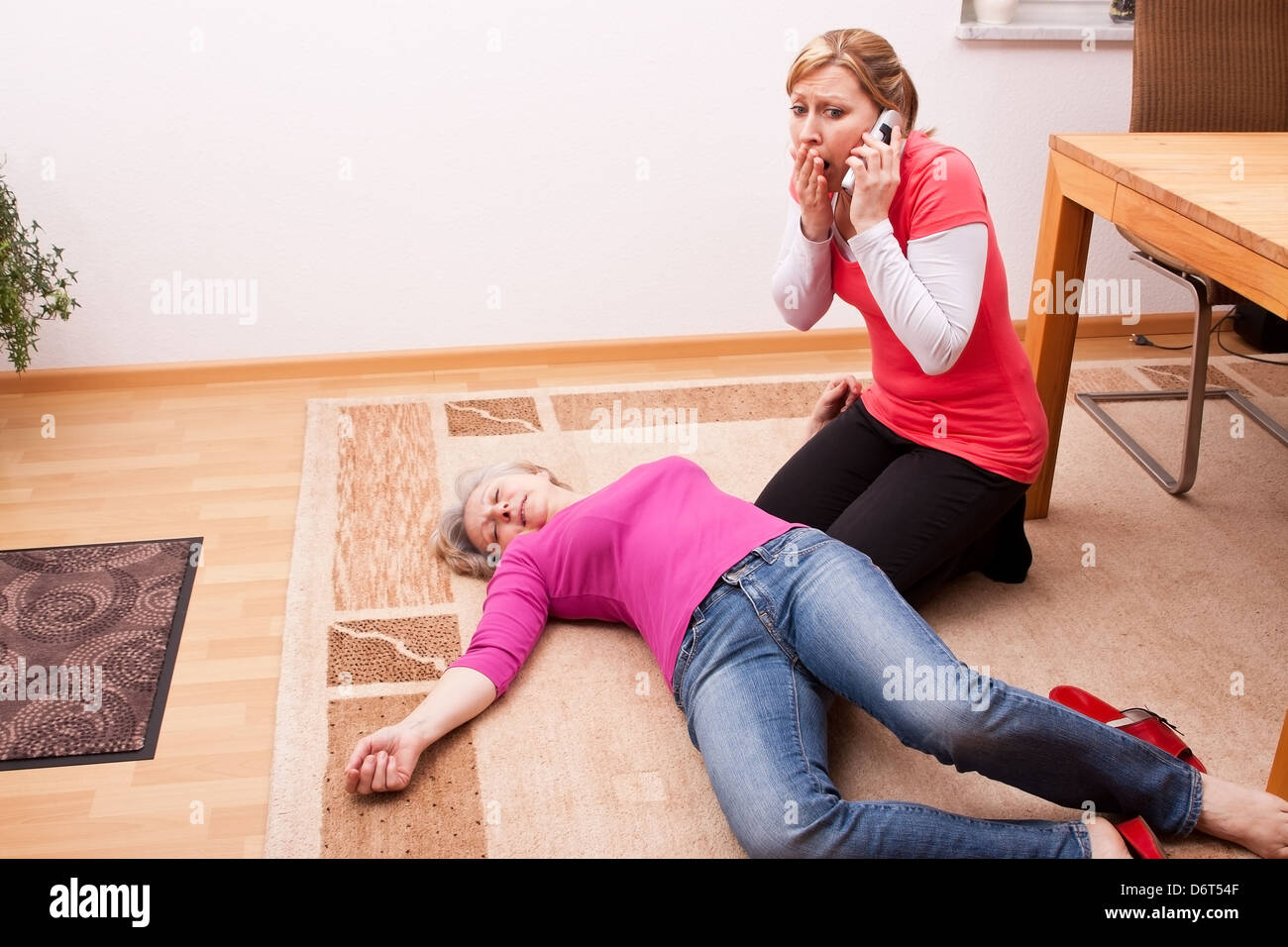 female senior collapsed young woman calling help Stock Photo - Alamy