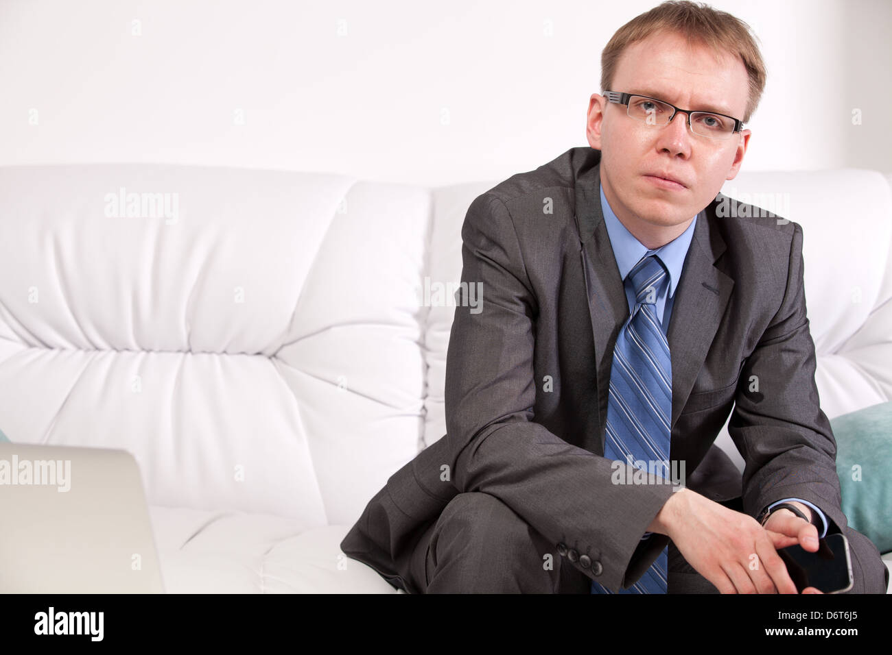 Man sitting on sofa Stock Photo - Alamy