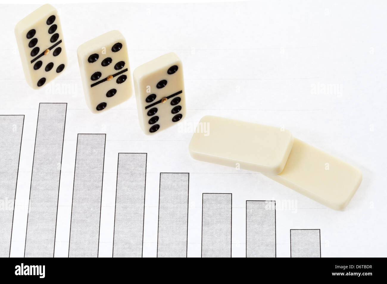 business concept - fallen domino and graph of decline economy results ...