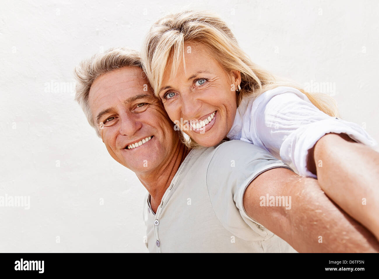 Mature couple smiling and embracing Stock Photo - Alamy