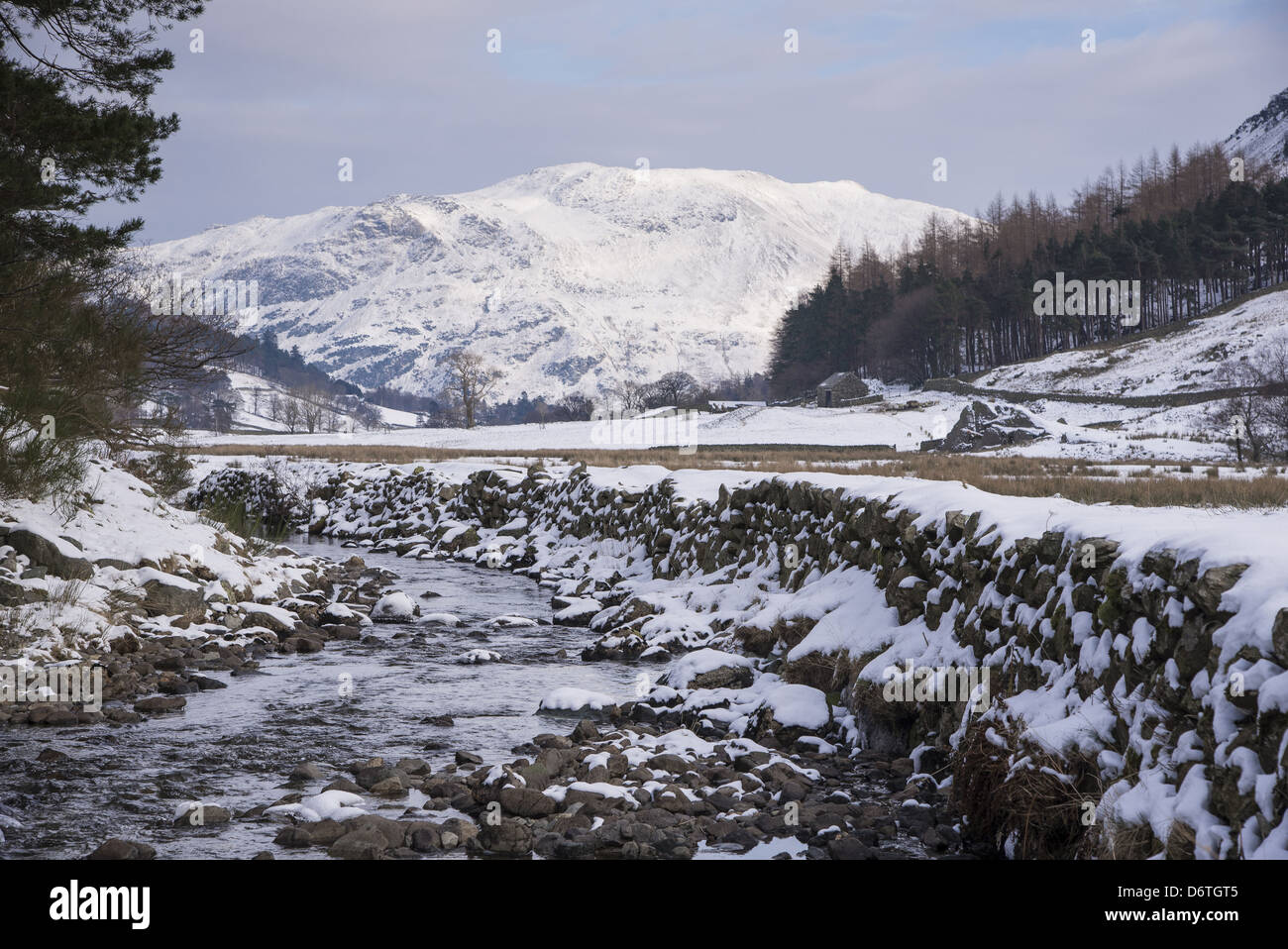 View stream flowing through snow covered upland landscape Grisedale ...