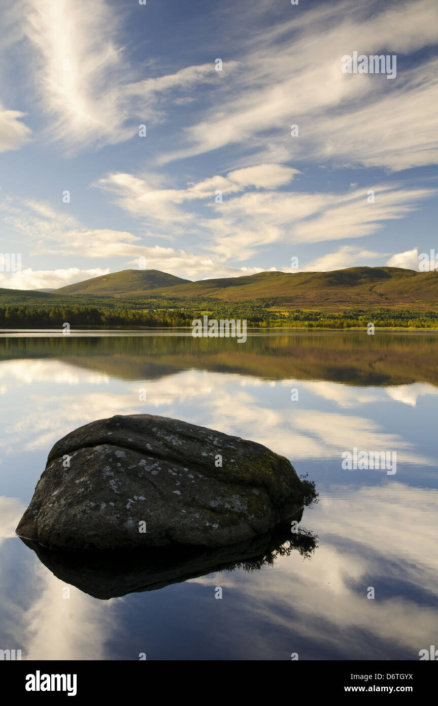 View blue sky clouds rock reflected in still water freshwater loch Loch ...