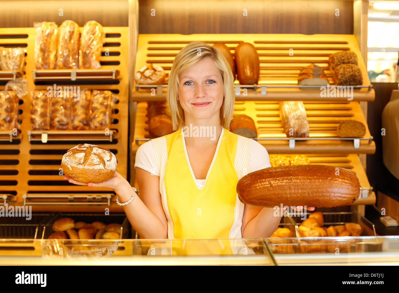 Shopkeeper in bakery with two loafs of bread Stock Photo - Alamy