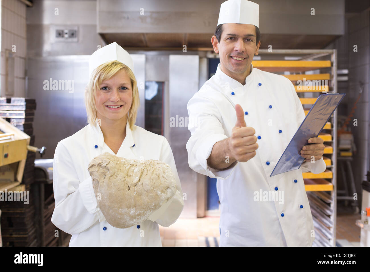 Baker presenting fresh bread dough in bakery or bakehouse Stock Photo ...