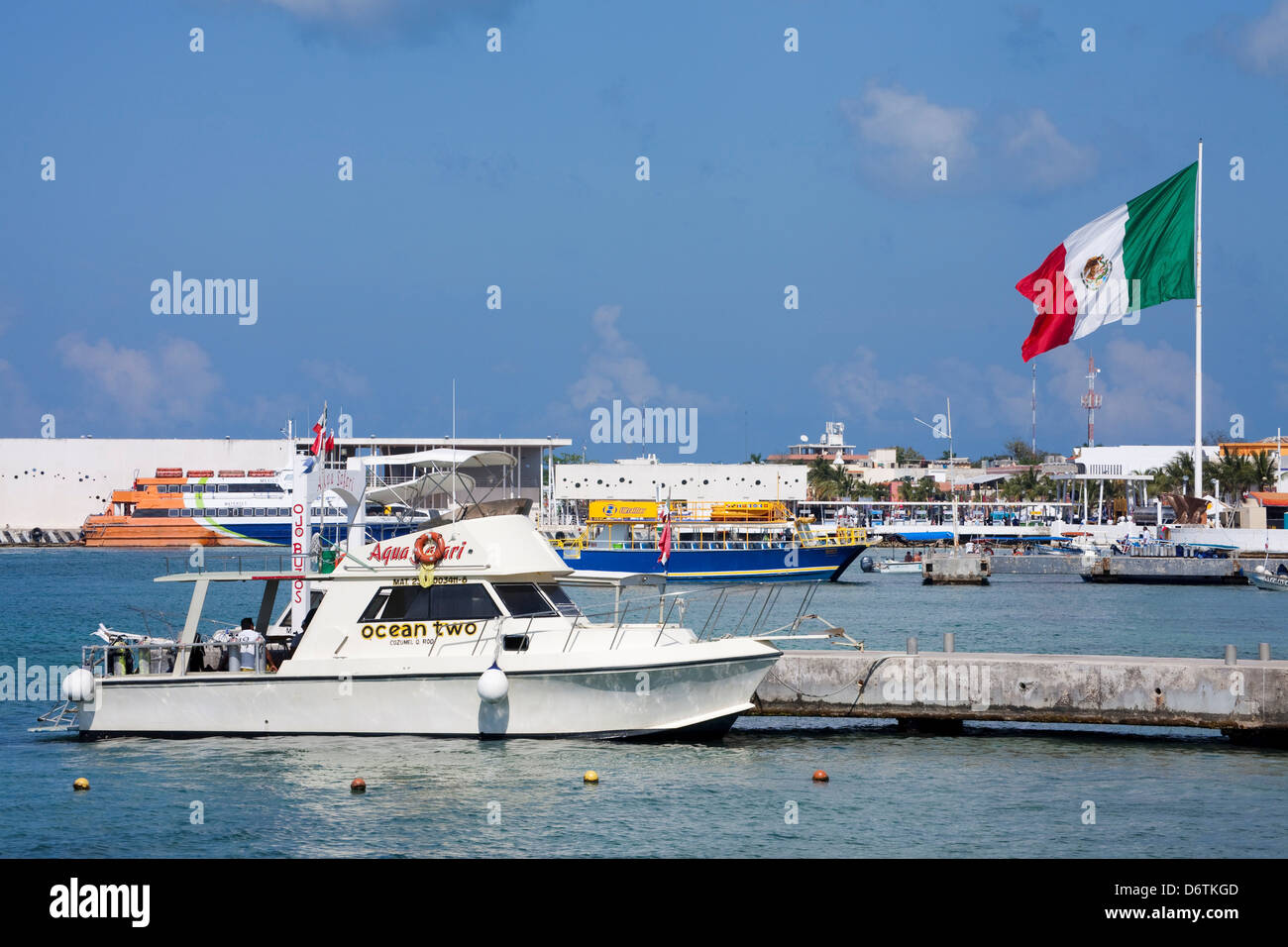 Boats at a pier with Mexican flag in the background, San Miguel ...