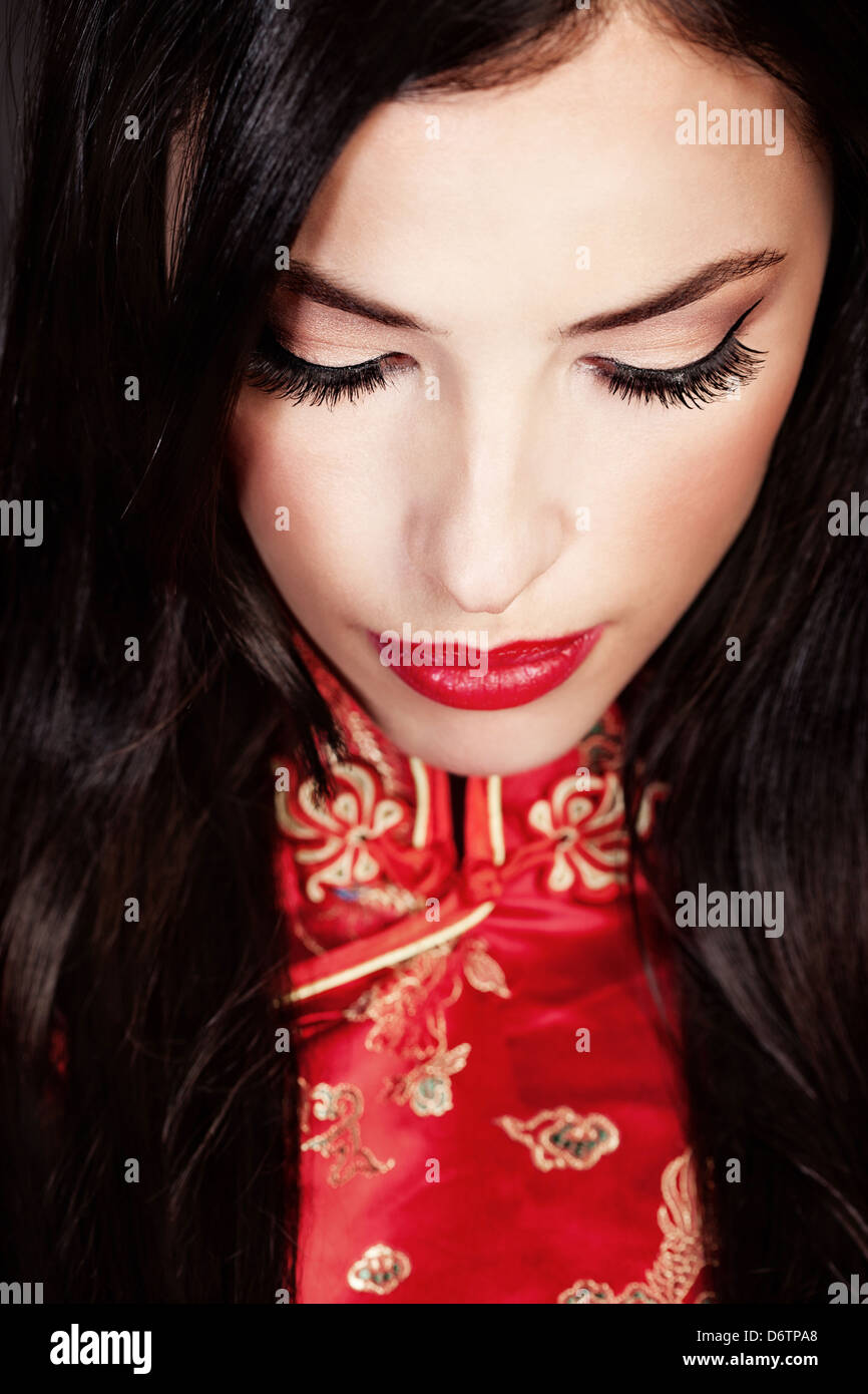pretty woman in red Cheongsam on dark background Stock Photo - Alamy