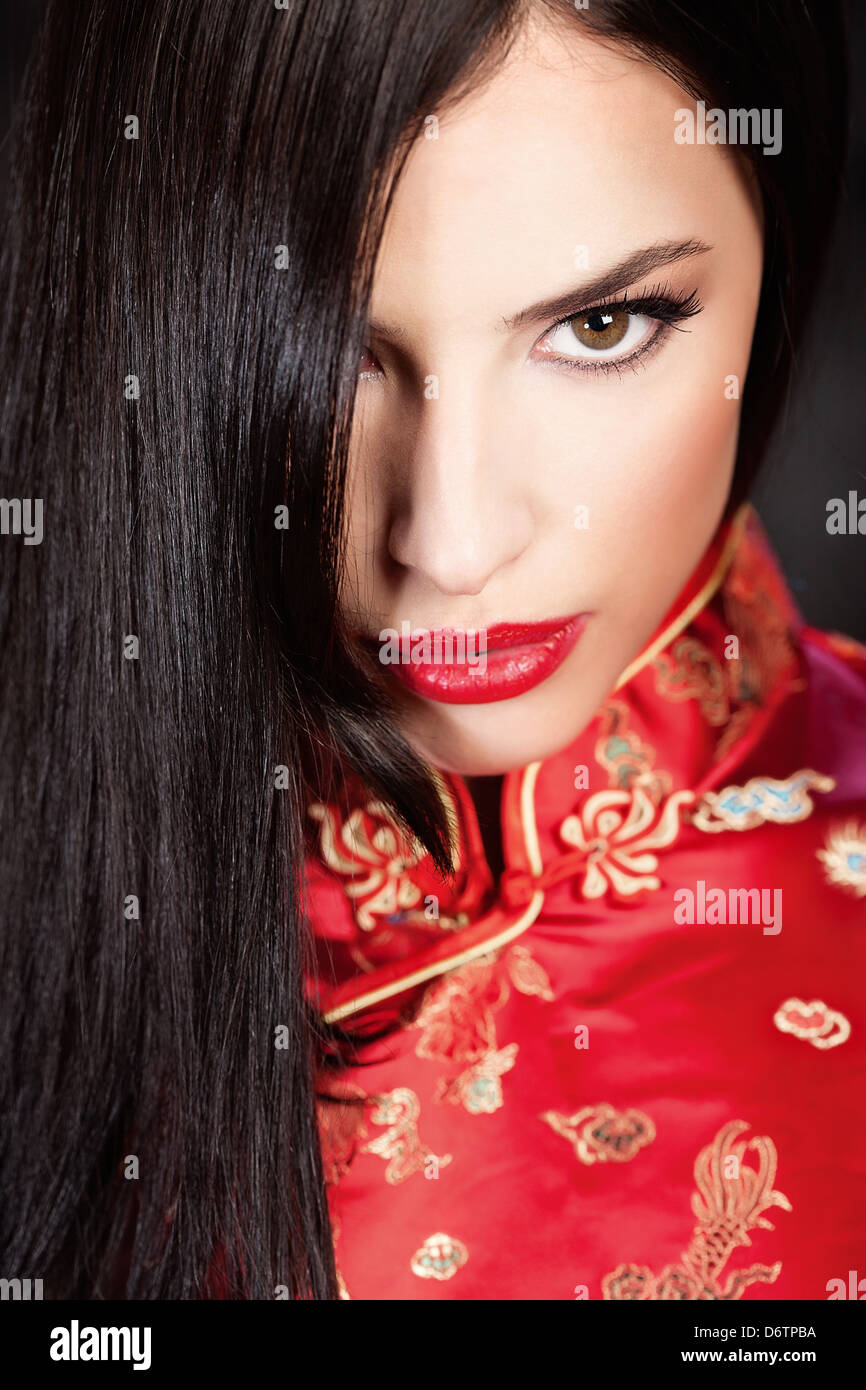 pretty woman in red Cheongsam on dark background Stock Photo - Alamy