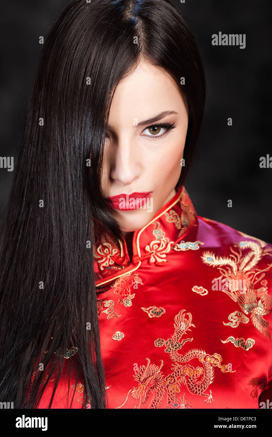 pretty woman in red Cheongsam on dark background Stock Photo - Alamy