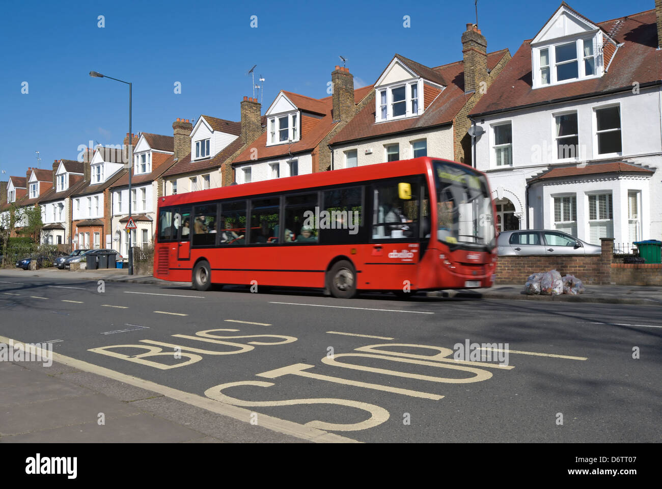 bus travelling on a street lined by 19th century houses in twickenham ...