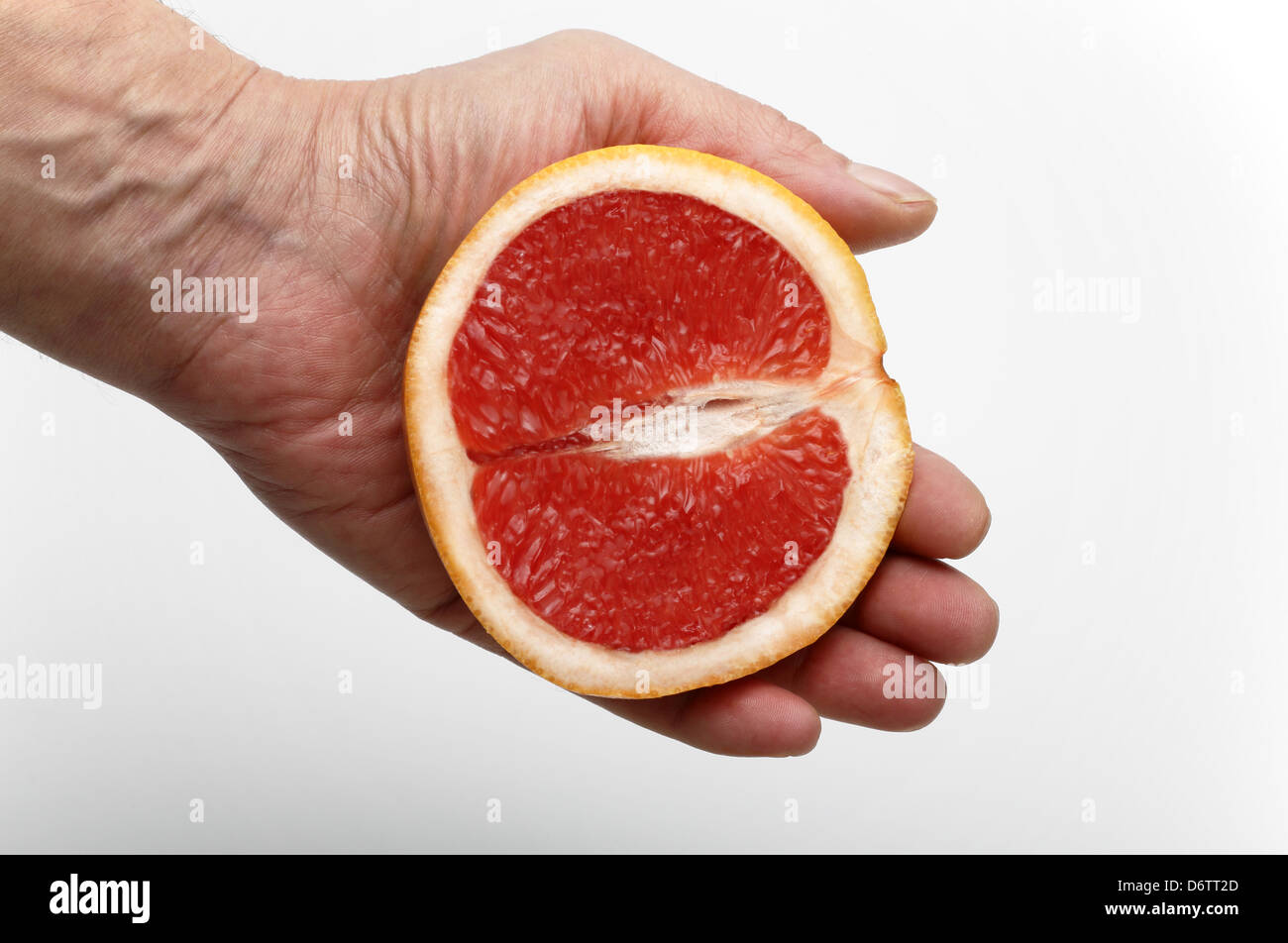 A red grapefruit held in a man's hand Stock Photo - Alamy
