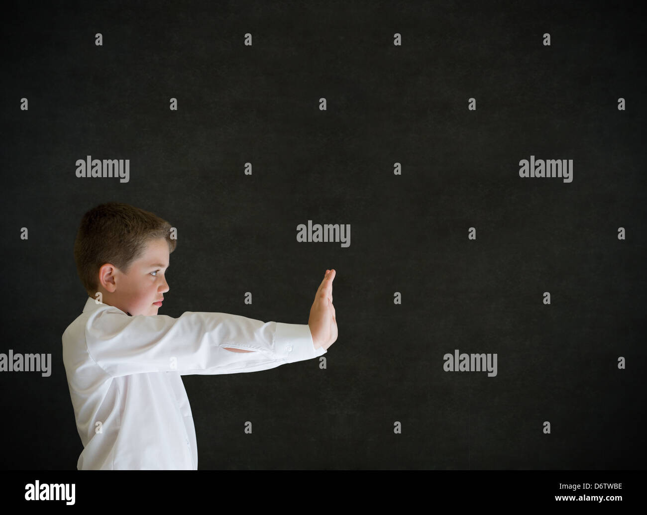 Boy dressed up as business man, teacher or school student pushing on ...