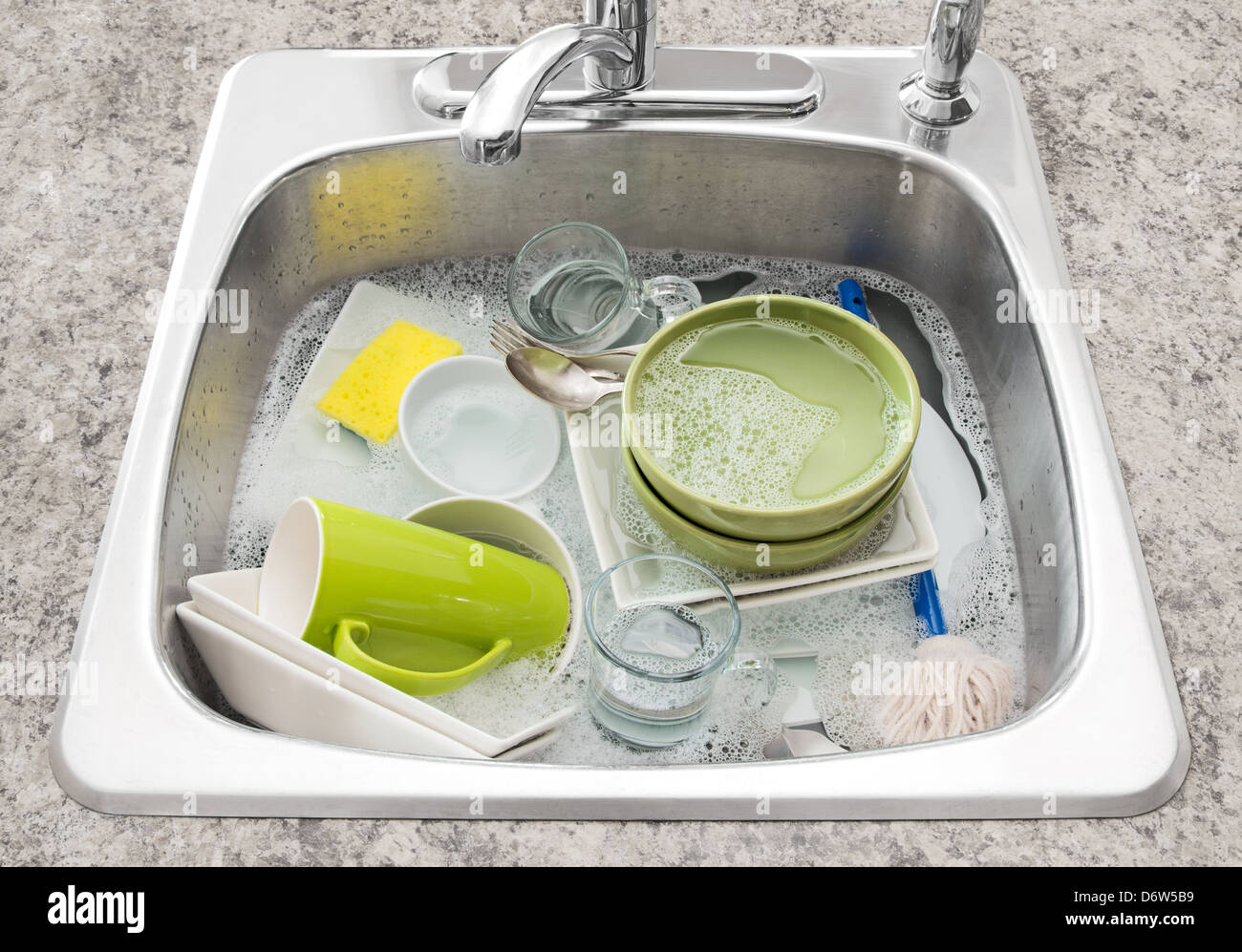 Dishwashing. Bright dishes soaking in the kitchen sink Stock Photo - Alamy