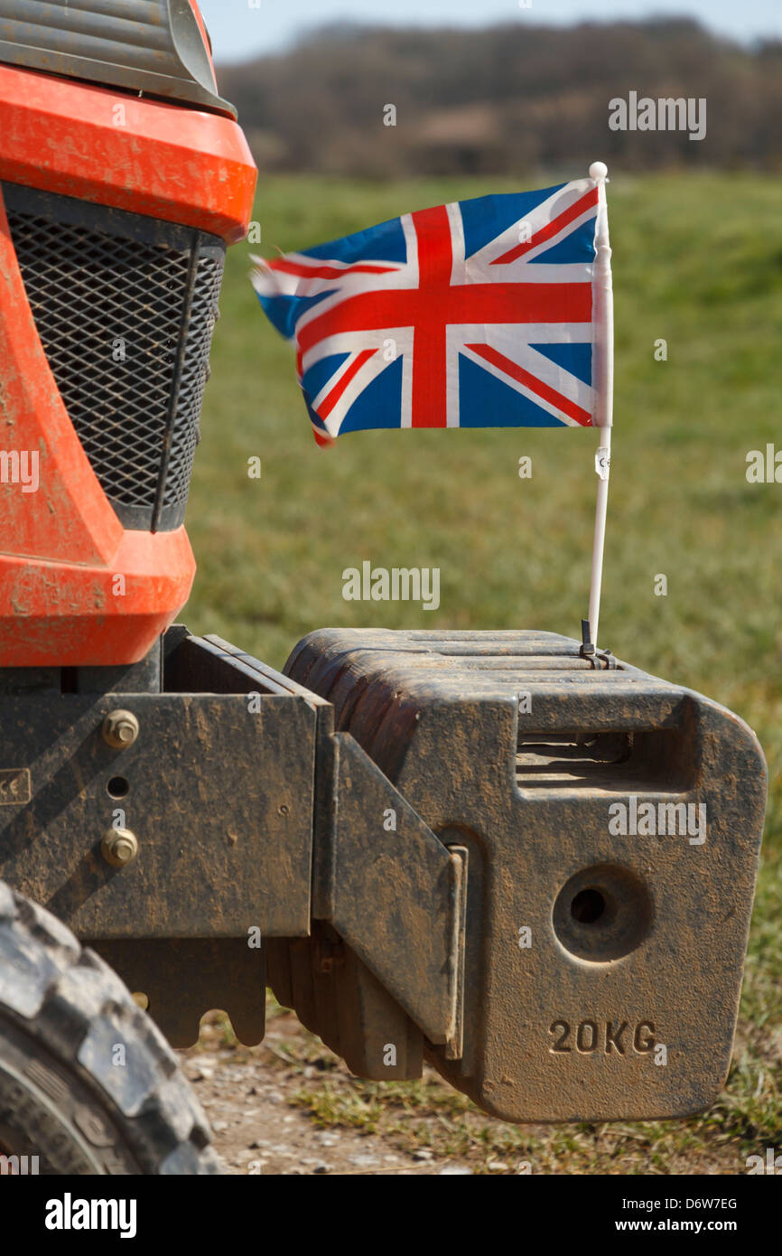 A union jack British flag on the front of a small red tractor lawnmower ...