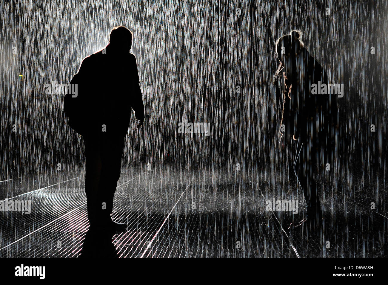 Two people in silhouette in the "rain room" at the Barbican centre ...