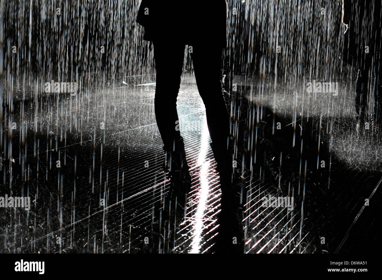 A woman in silhouette in the "rain room" at the Barbican centre Stock ...