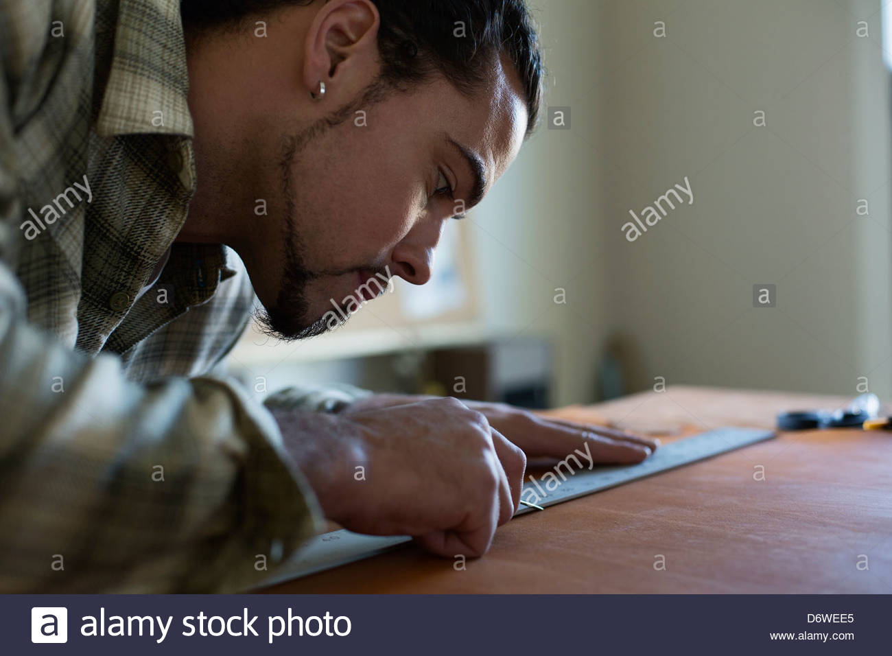 Mid adult man measuring leather with ruler in workshop Stock Photo - Alamy