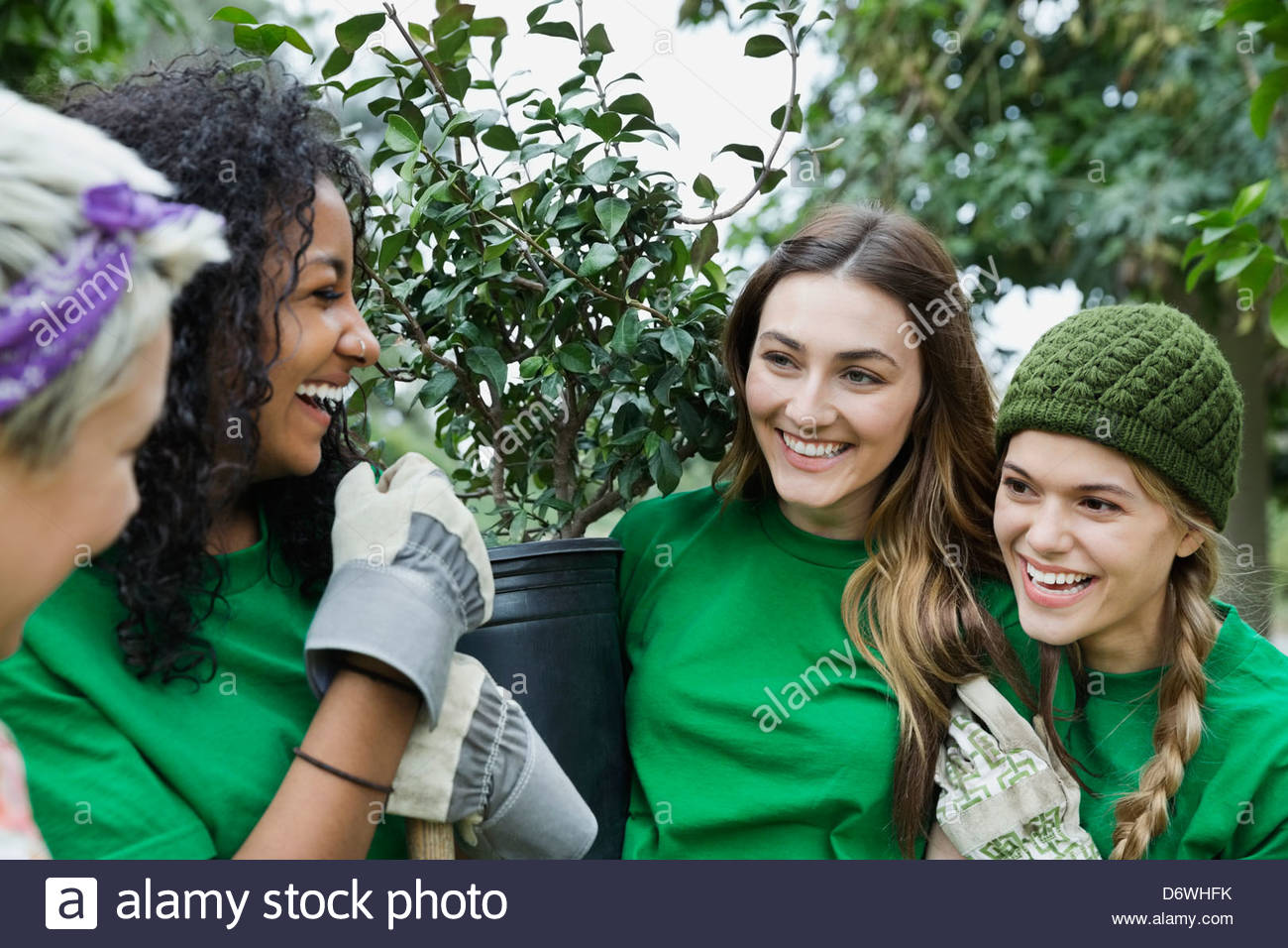 Group of happy female environmentalists with potted plant in park Stock ...