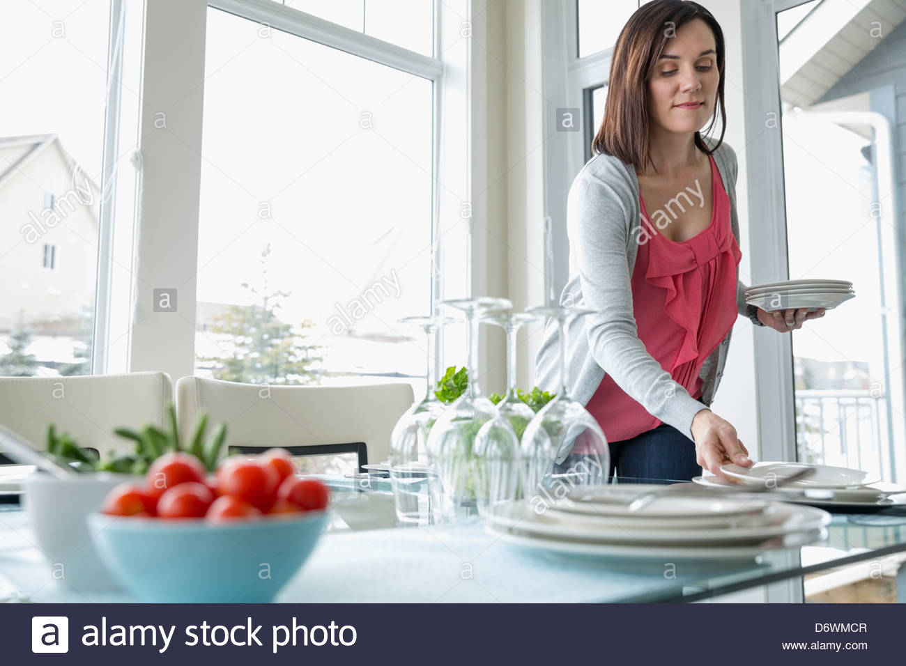 Mature woman arranging plates dinner hi-res stock photography and ...