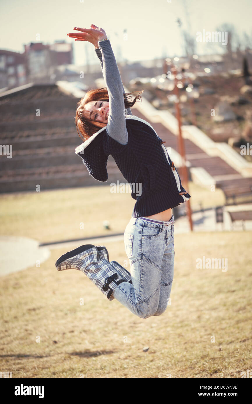 Young happy girl jumping in spring park Stock Photo - Alamy
