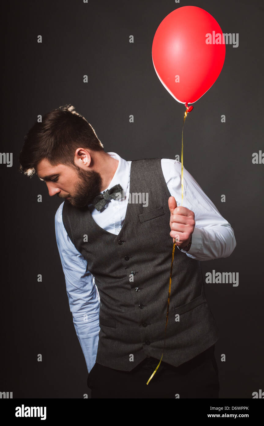 Vintage looking man with red balloon in his hand Stock Photo - Alamy