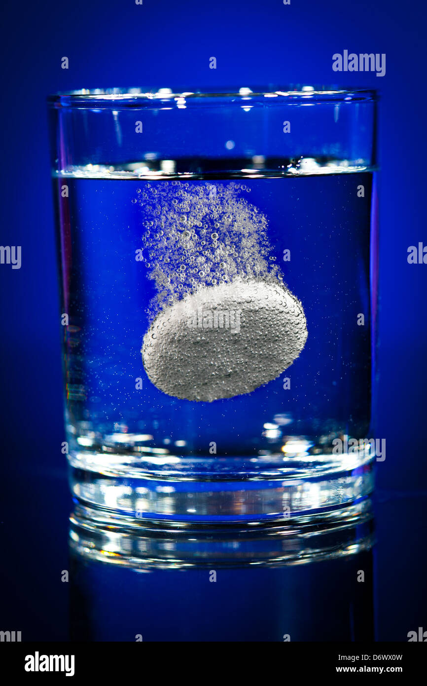 Effervescent tablet in water with bubbles on a blue background Stock ...