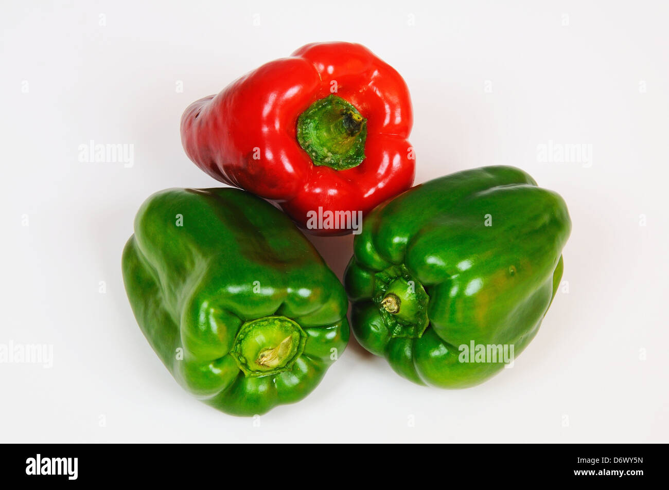 Two green and one red capsicum against a white background Stock Photo ...